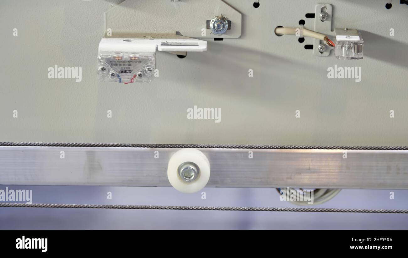 View inside of elevator mechanism with moving stretched metal cable ...