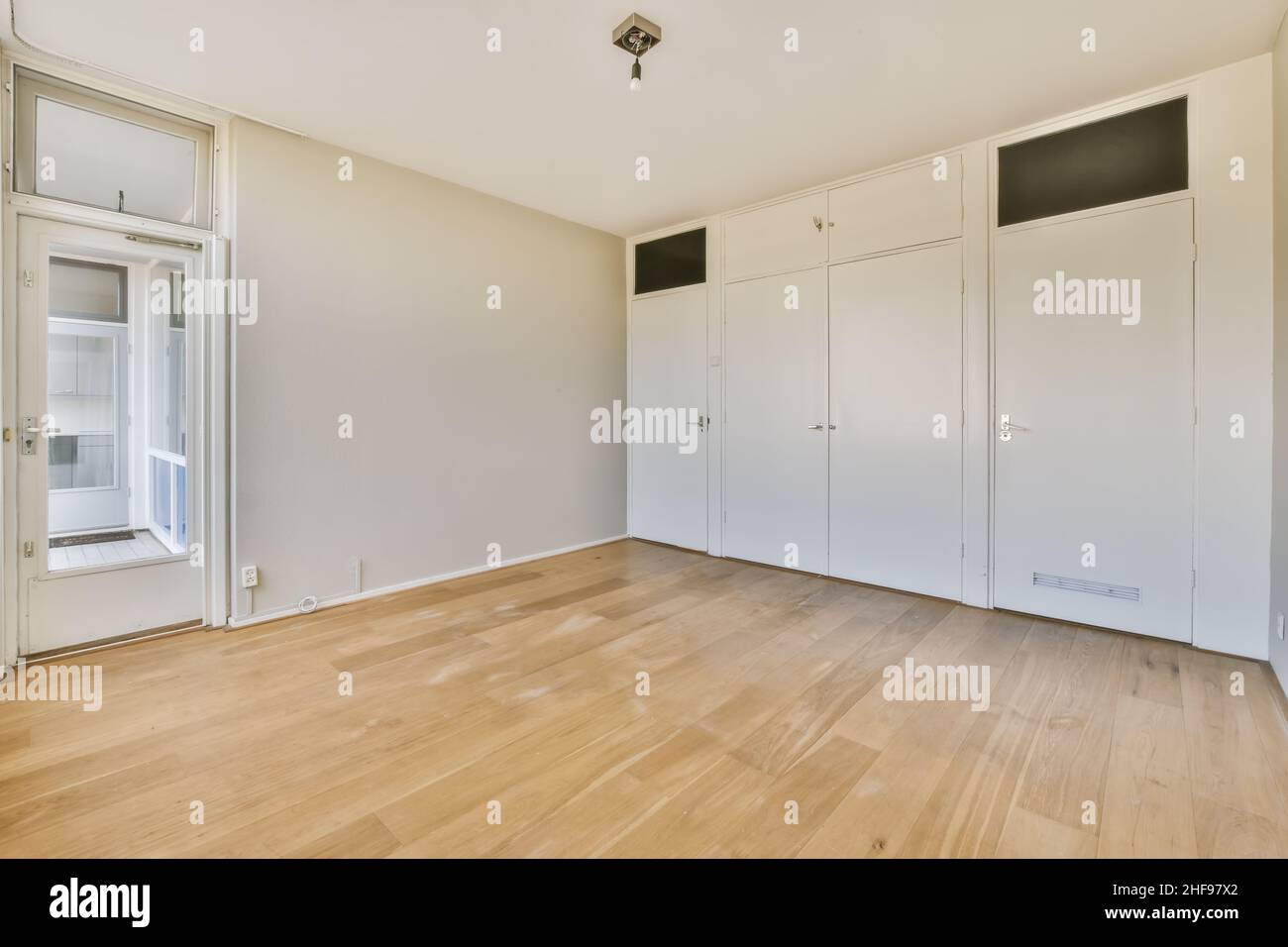 Empty large room of luxury house with wooden flooring and white walls ...