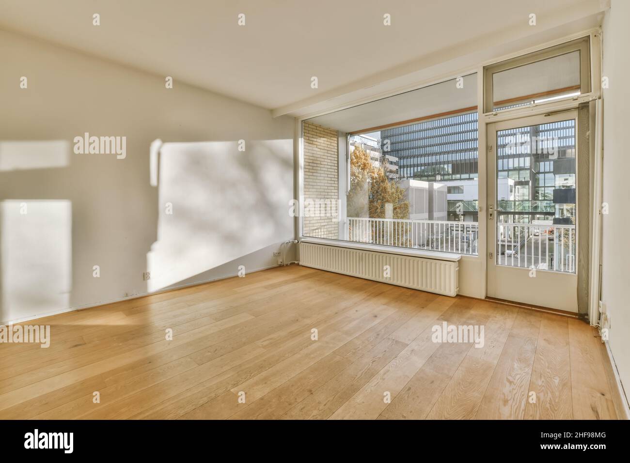 Empty large room of luxury house with wooden flooring and white walls ...