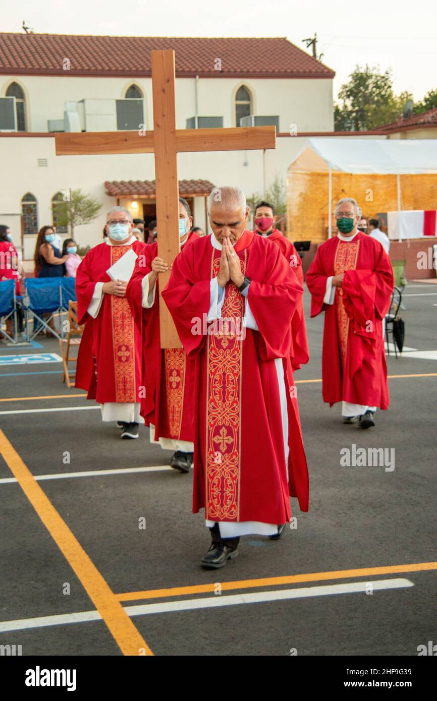 As part of an outdoor mass, multiracial robed priests form a procession ...