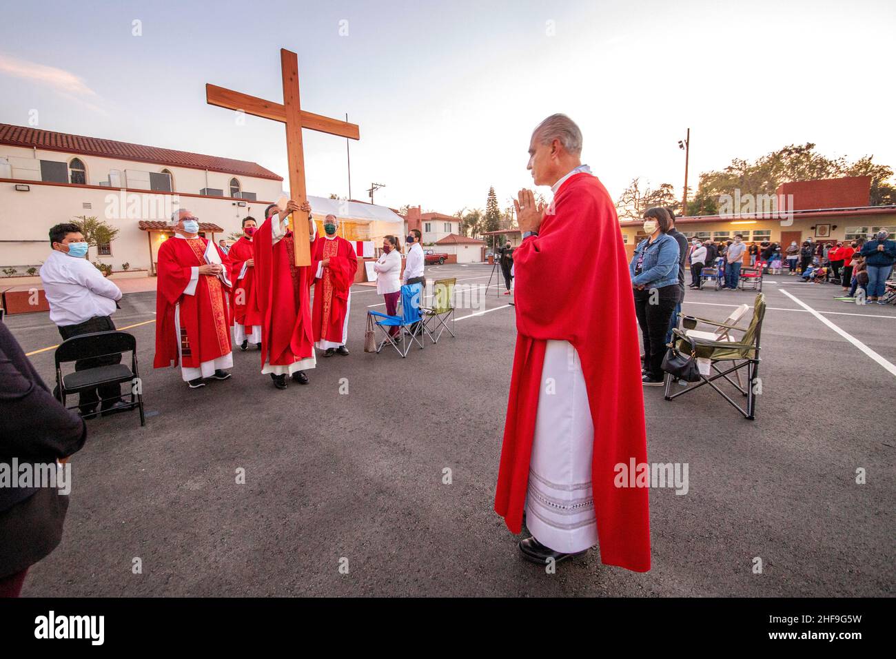 As part of an outdoor mass, multiracial robed priests form a procession ...