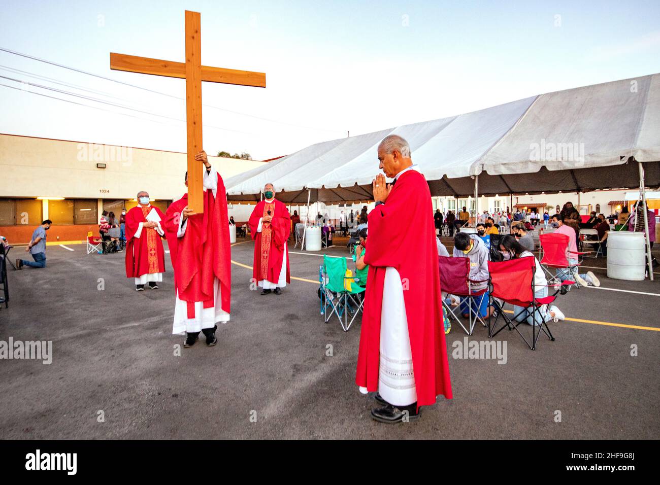 As part of an outdoor mass, multiracial robed priests form a procession ...