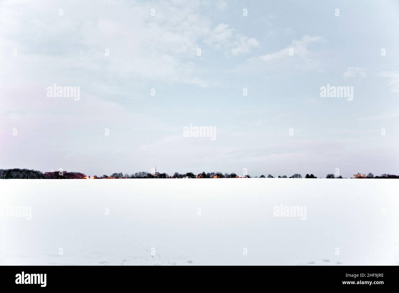 fiew over snow covered acres to skyline of city with antenna for mobile ...
