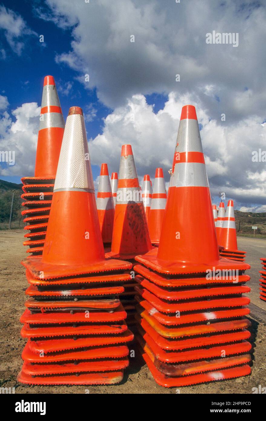 Striped orange traffic cones are stacked near a road worksite in Laguna ...