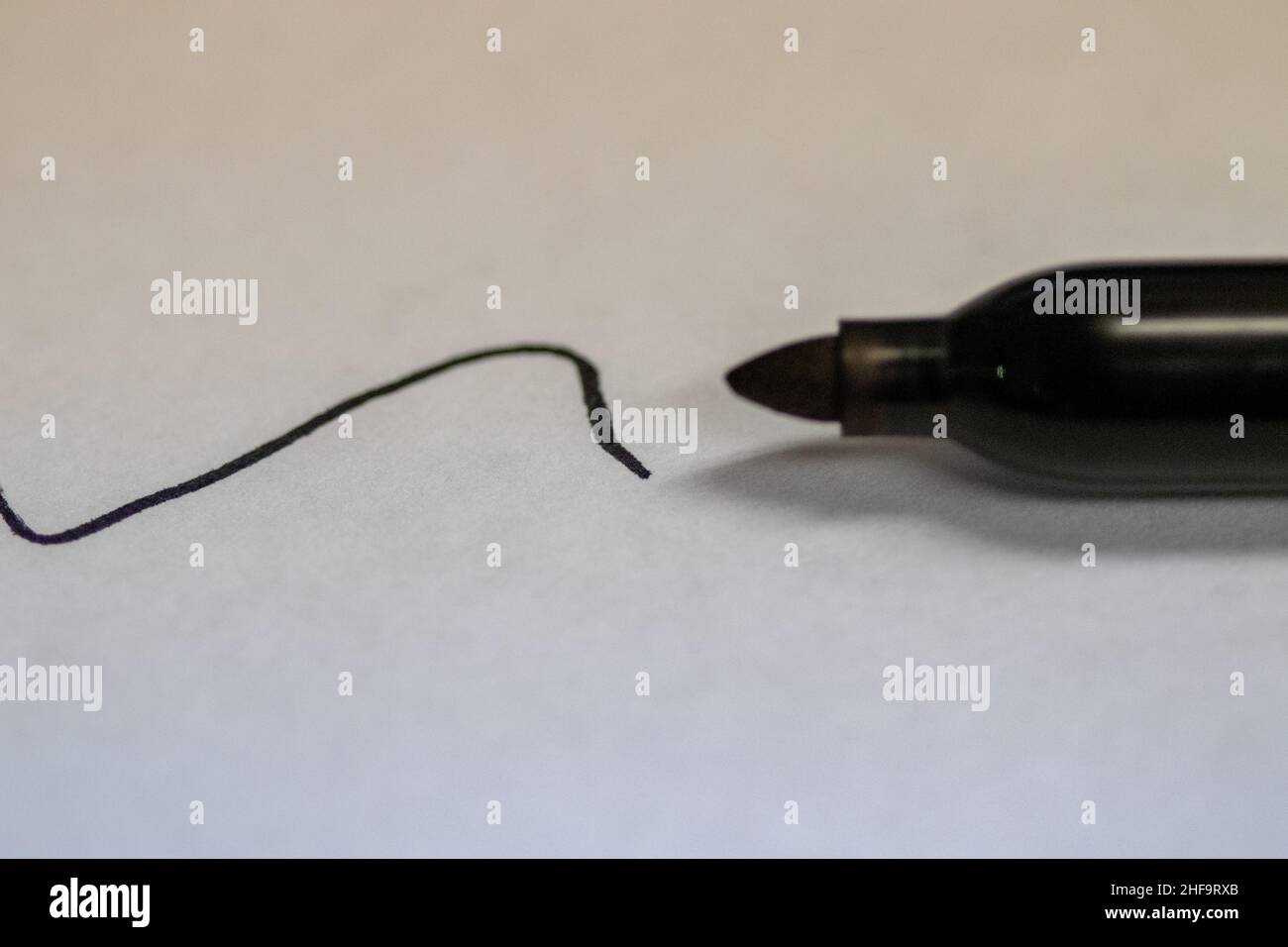 Permanent sharpie Marker close up written black line on white paper ...