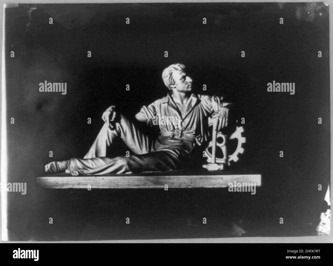 Sculpture of man with a hammer leaning on a gear Stock Photo - Alamy