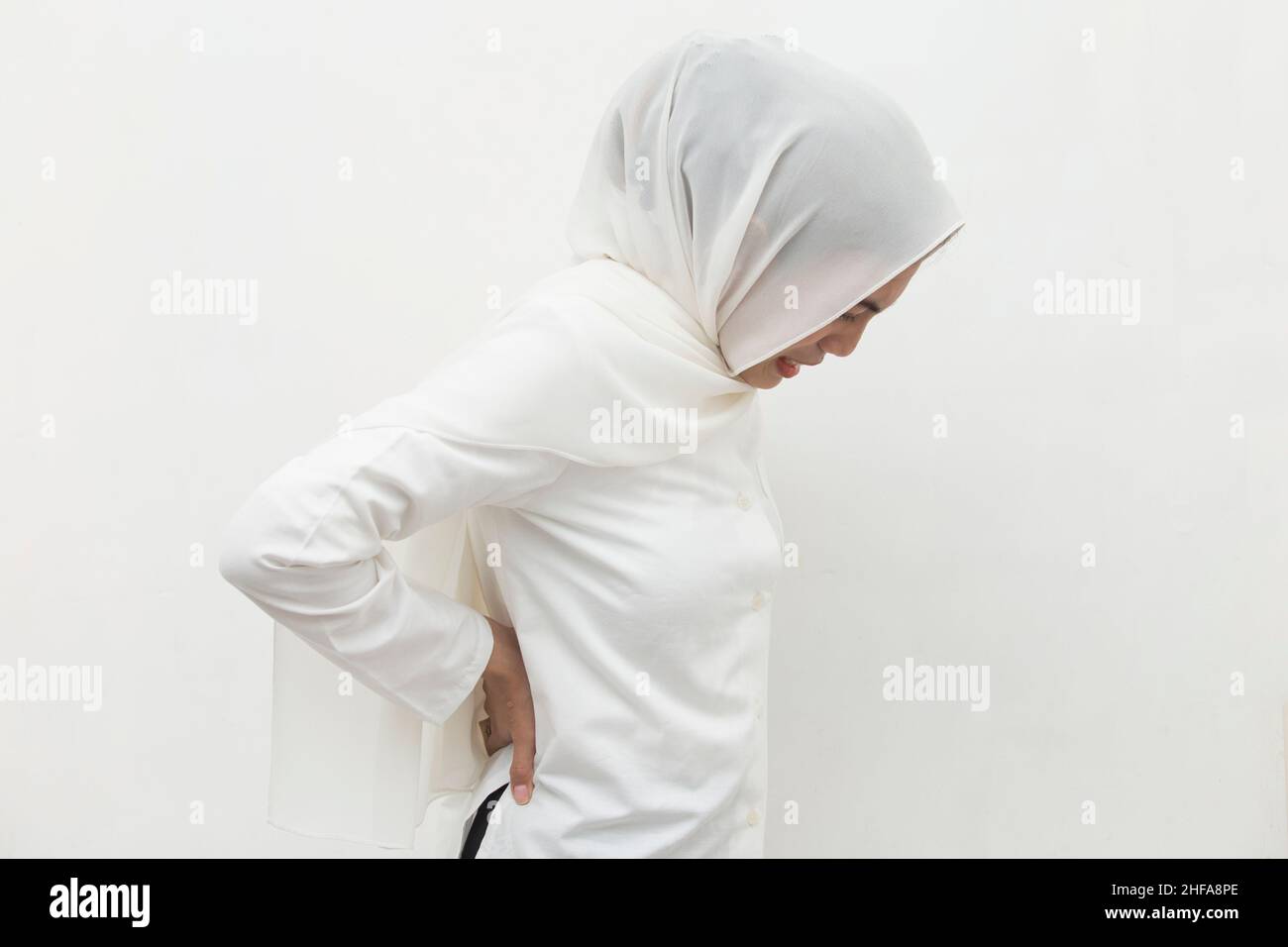 Young asian muslim woman suffering low back pain and waist lumbar pain ...