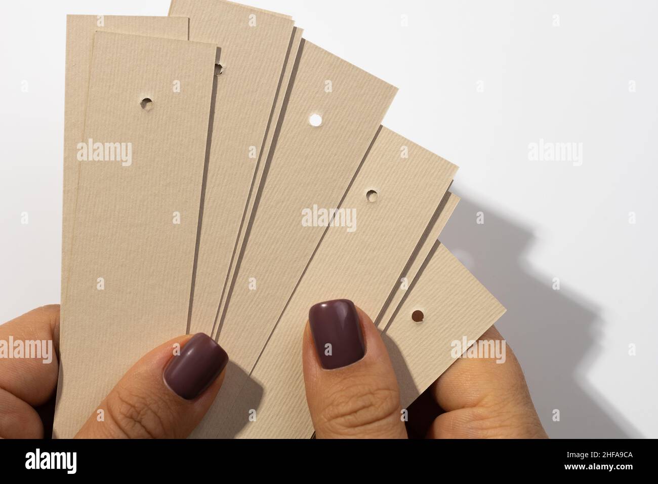 Bunch of blank cardboard rectangular tags with tiny holes in upper part ...
