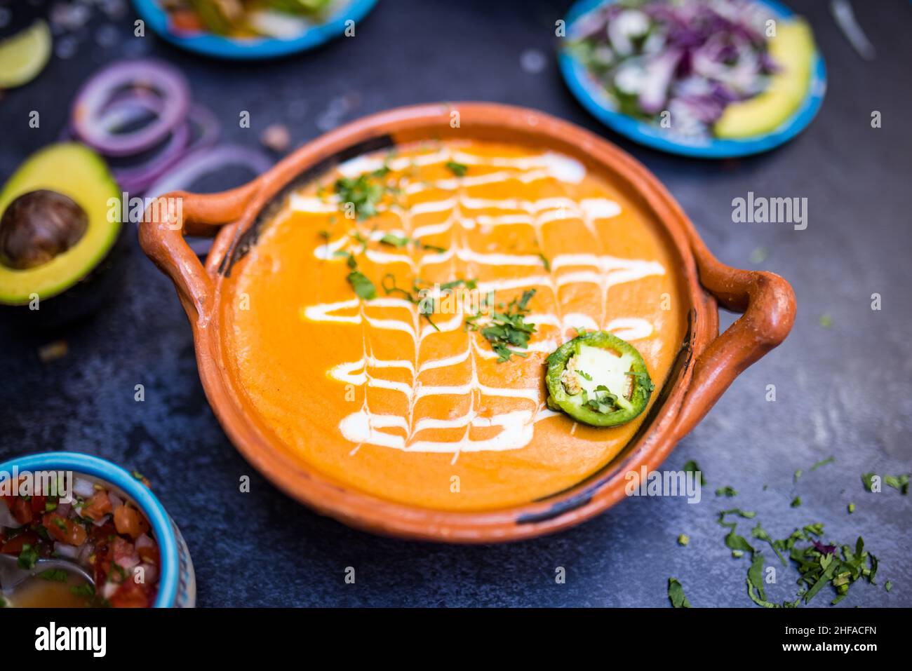Delicious soup in traditional clay pot above dark surface Stock Photo ...