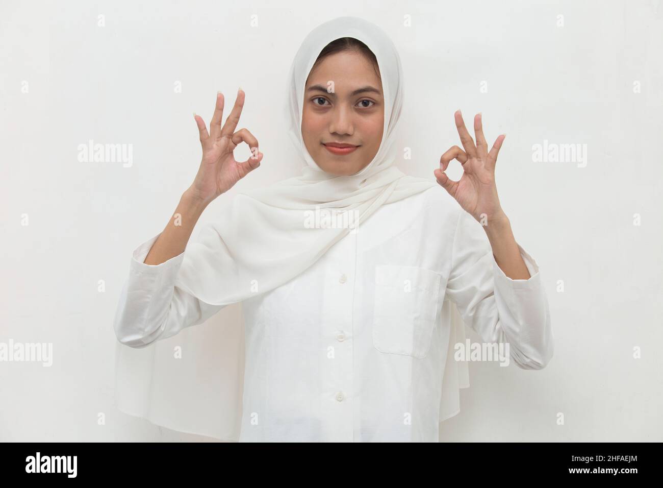 Asian muslim woman wearing hijab with ok sign gesture Stock Photo - Alamy