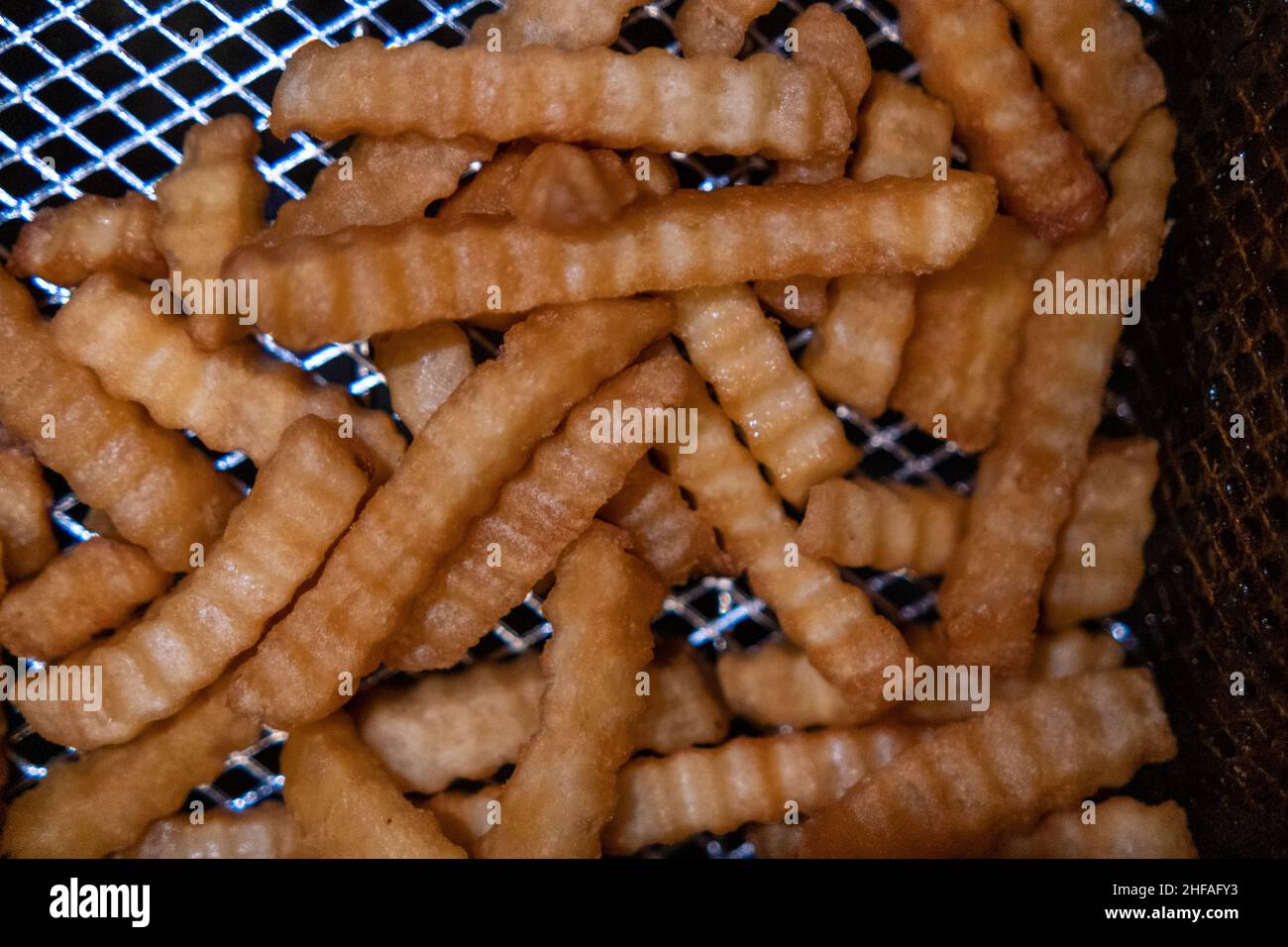 Top view of several wavy French fries in fryer basket Stock Photo - Alamy