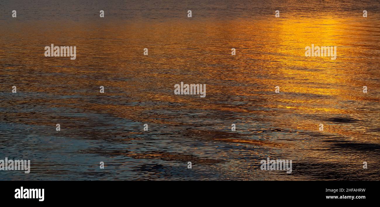 Golden water background during sunset or sunrise with waves, ripples ...