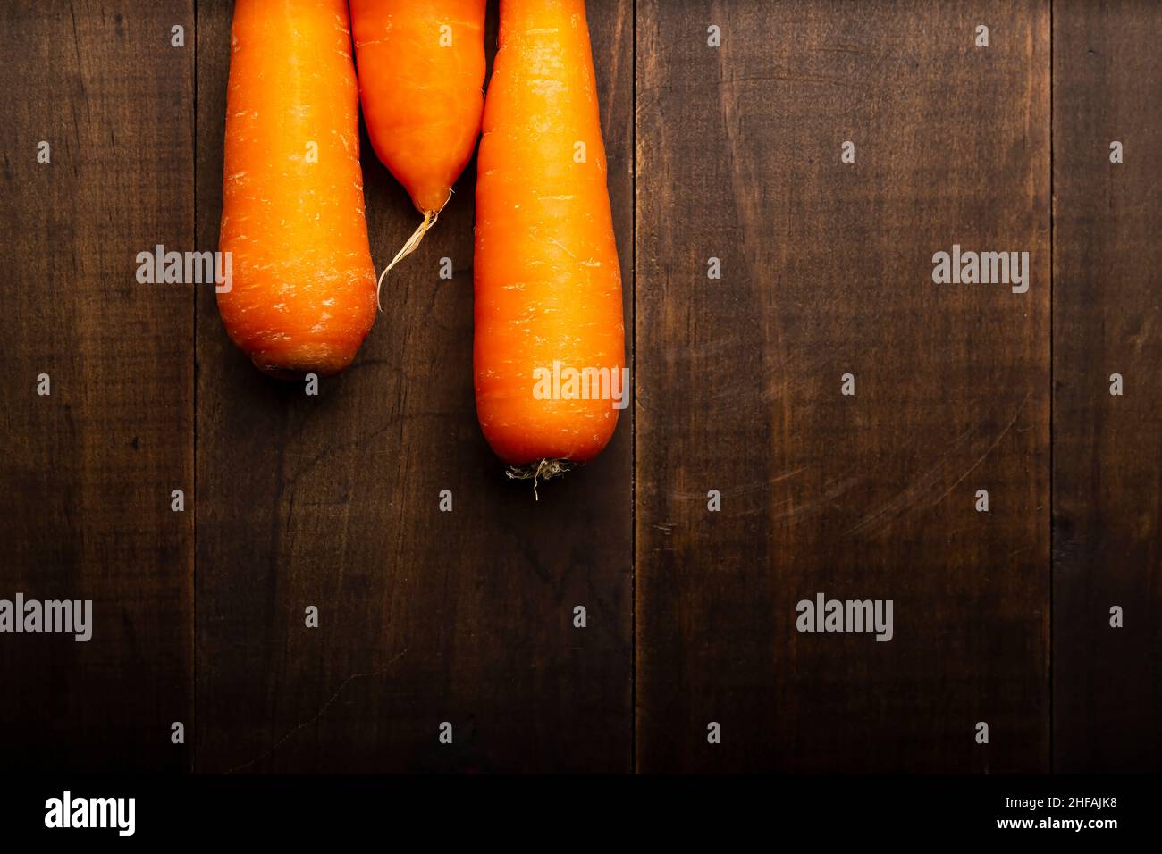 image of three carrots on rustic wooden background with copy space ...