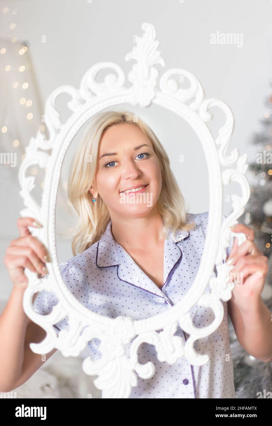 Young beautiful woman holding a frame in front of her face. Studio ...