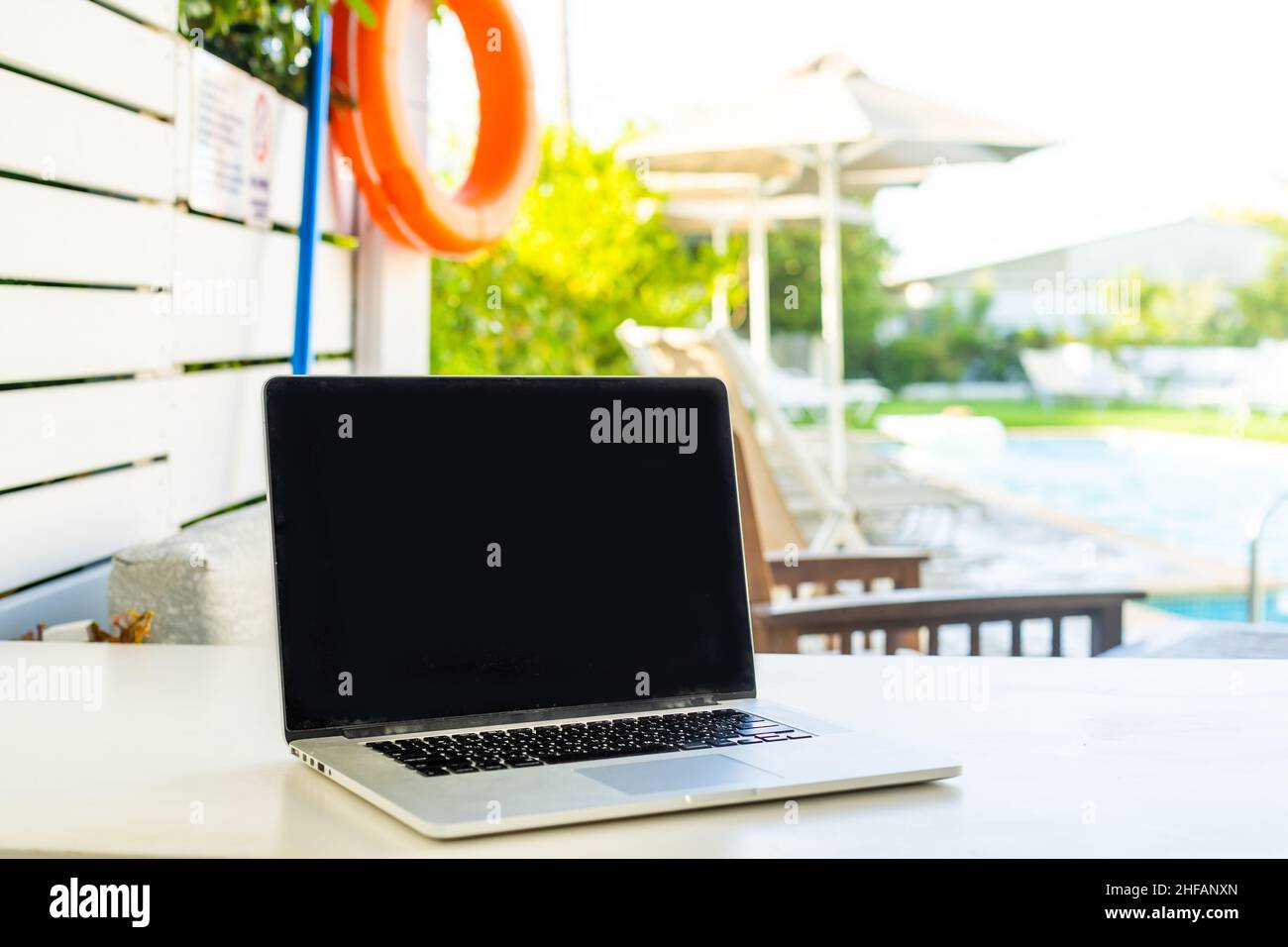 laptop computer on table pool background Stock Photo - Alamy