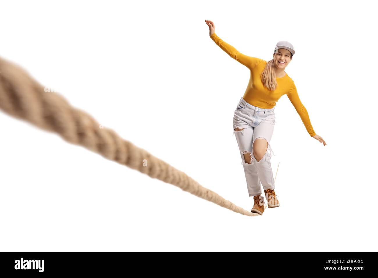 Full length portrait of a young female trying to walk on a tightrope ...