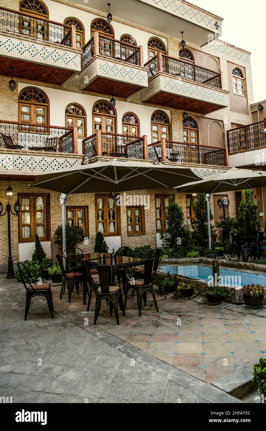 Inner courtyard with a garden and a cafe and the facade of a 3-storey ...