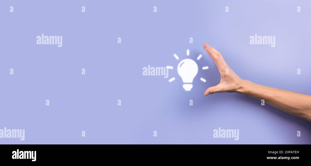 Hand hold light bulb. Holds a glowing idea icon in his hand. With a ...