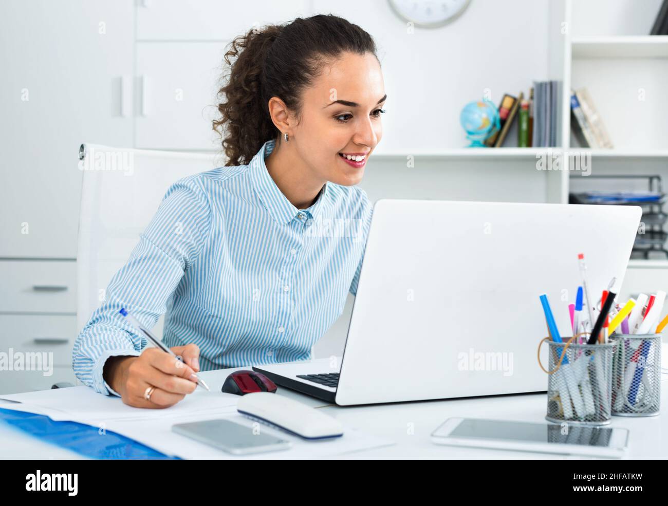 Business lady sitting at office desk with laptop Stock Photo - Alamy