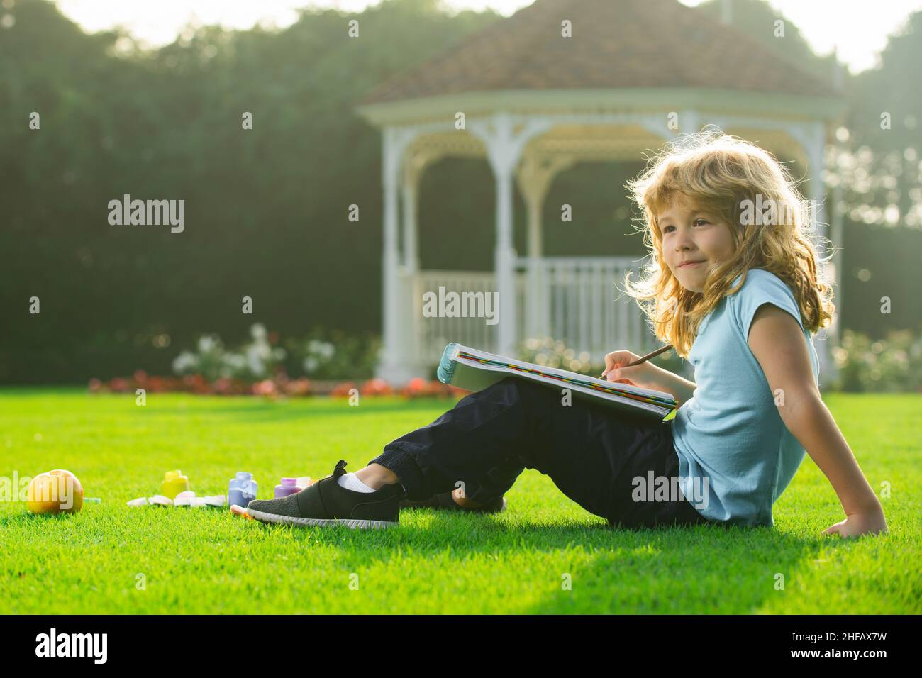 Kid draws in park having fun on nature background. Children creative ...