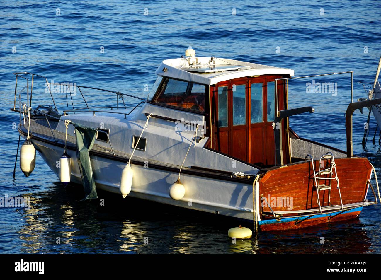 An old type of sport yacht boat anchored in the harbor on a sunny day ...