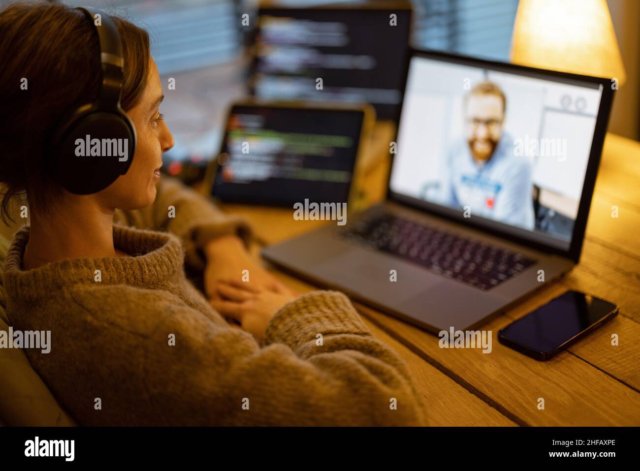 Woman talking online with a male colleague at home office Stock Photo ...