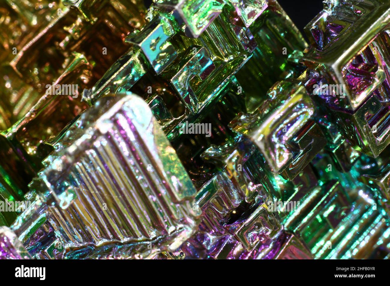 Synthetic bismuth (Bismuthum) crystal with rainbow oxide film close up ...