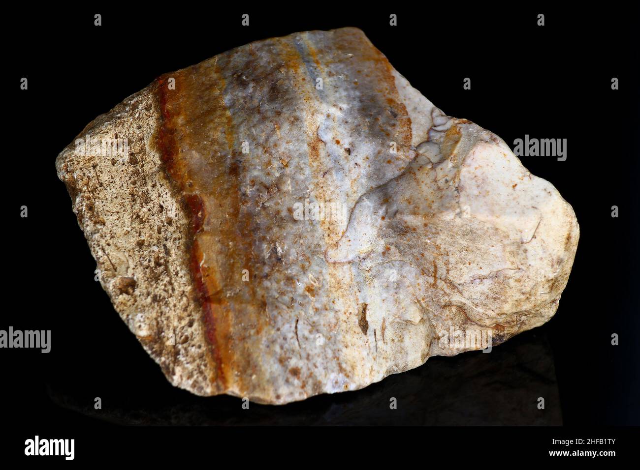 Sample of raw flint with stripes of different shades on a black ...