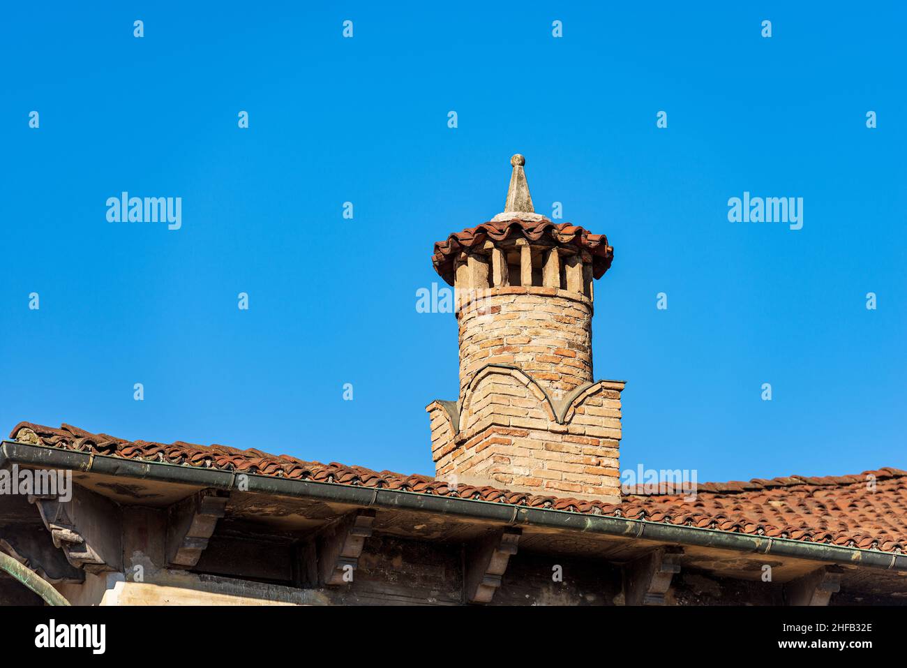 Close-up of an ancient chimney made of a bricks on a clear blue sky, on ...