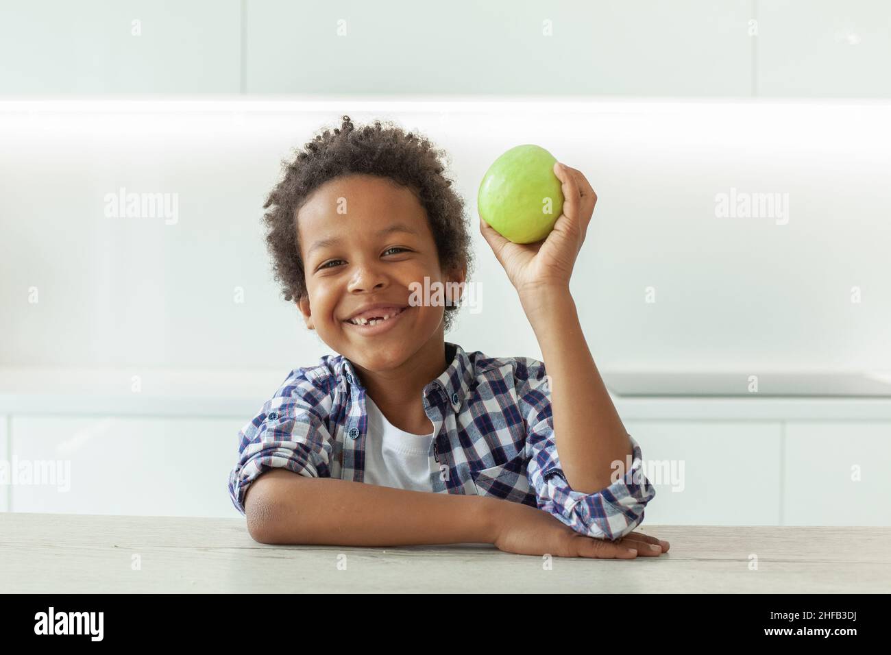 Happy small boy laughing and holding green apple. Healthy food and ...