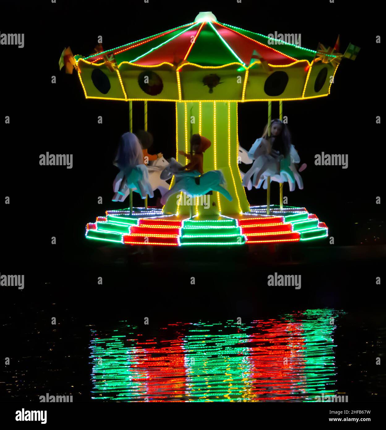 Spinning Illuminated roundabout on the river Derwent in Matlock Bath as ...