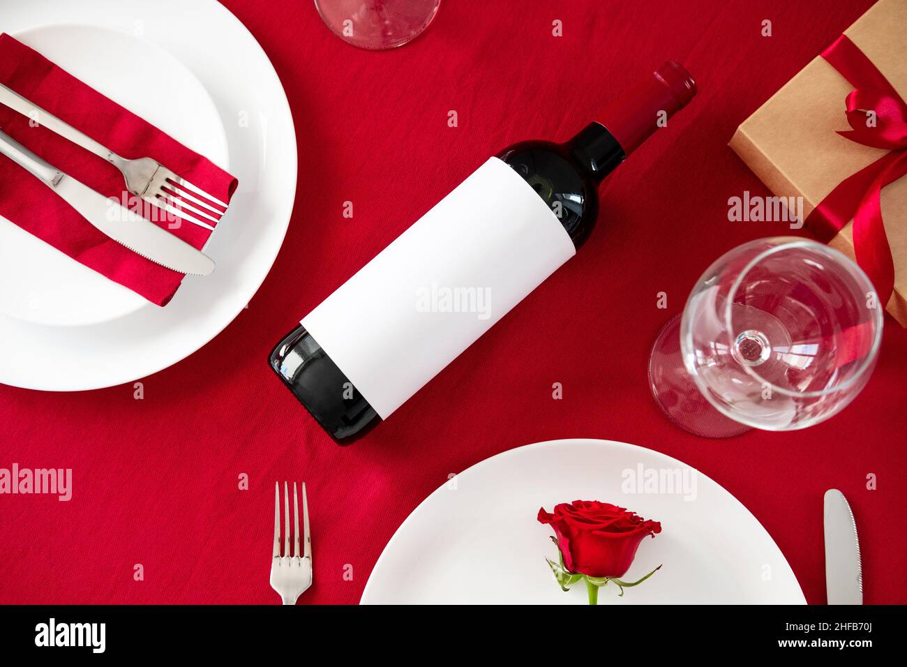 Romantic Valentines Day dinner setting table. Wine bottle with blank ...