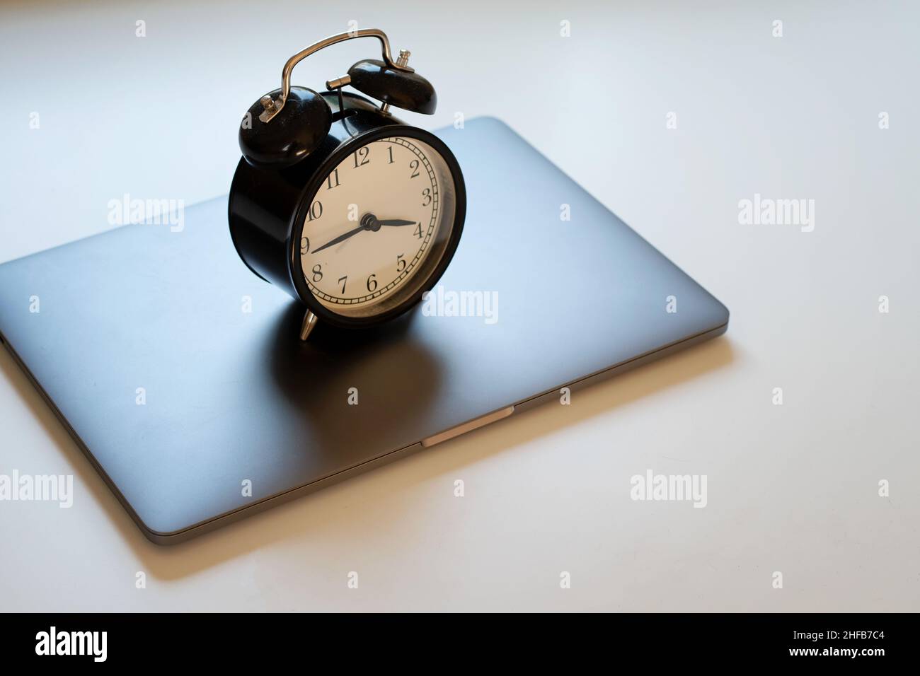 Alarm clock standing on laptop. Concept of work hours, deadline and ...