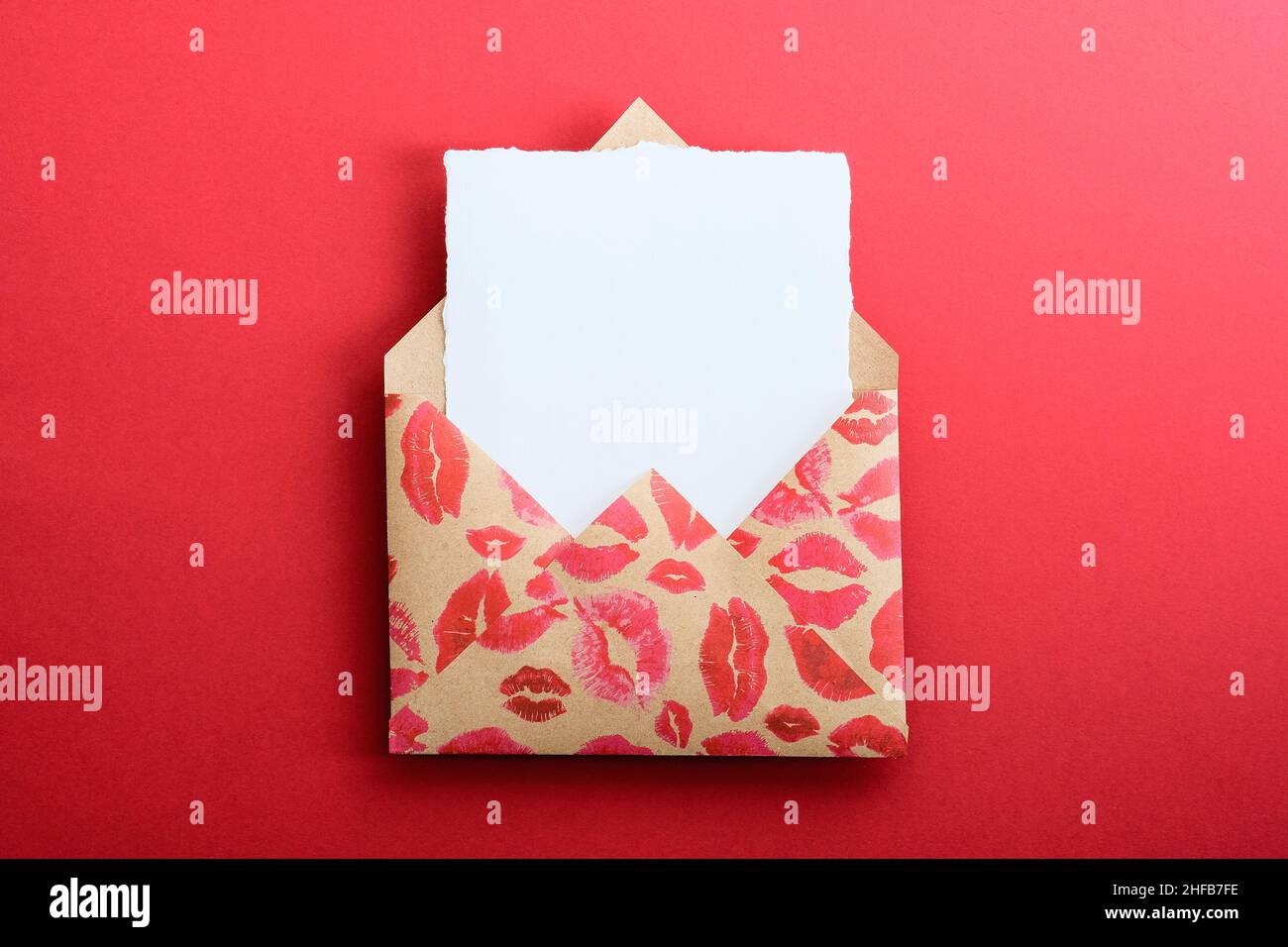 Craft paper envelope with lipstick marks and blank paper note inside on ...