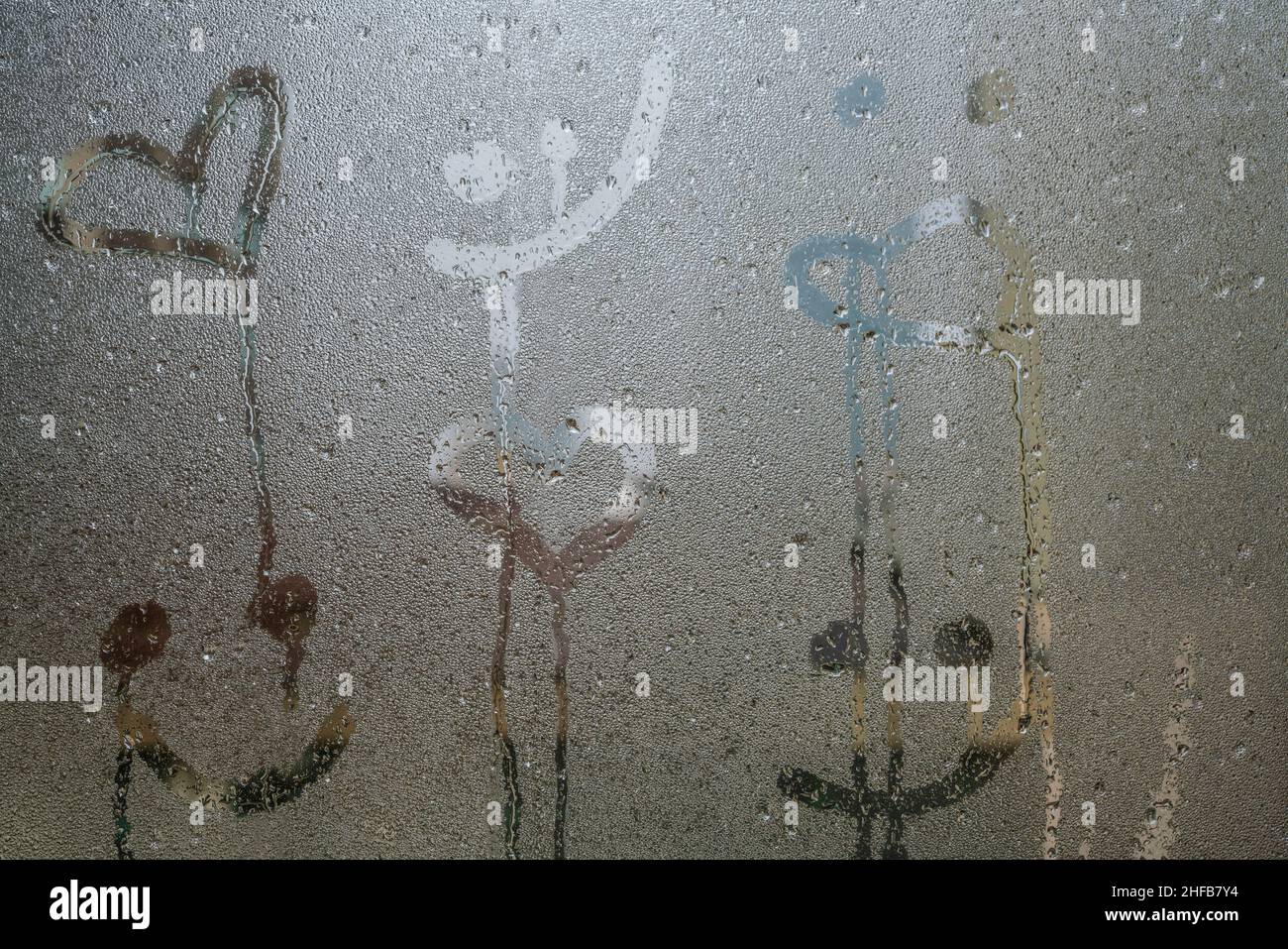 steamed glass, hand drawn smiling face and heart shapes on steamed ...