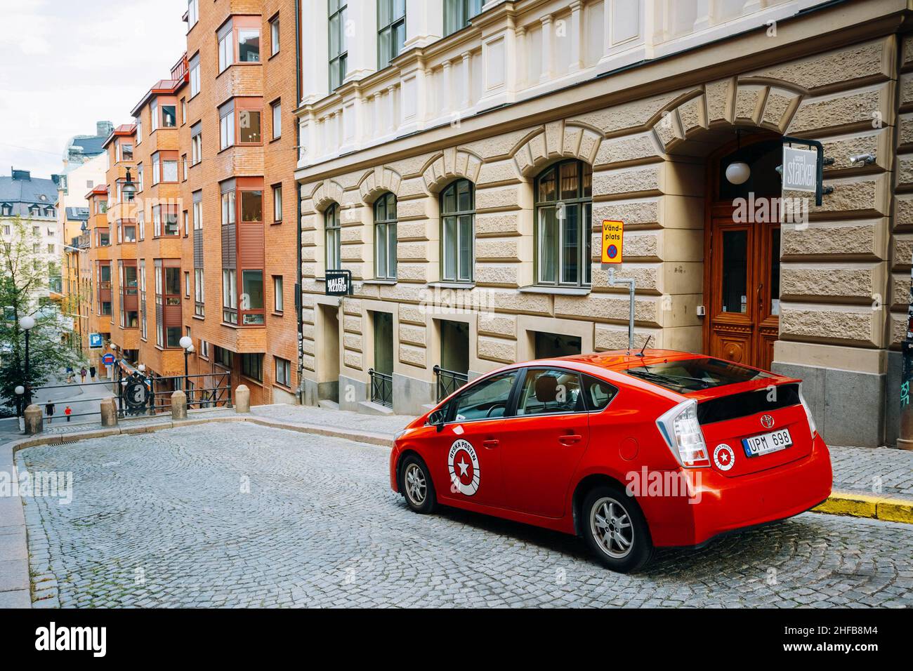 Red color Toyota Prius car parked at sidewalk on the David Bagares ...