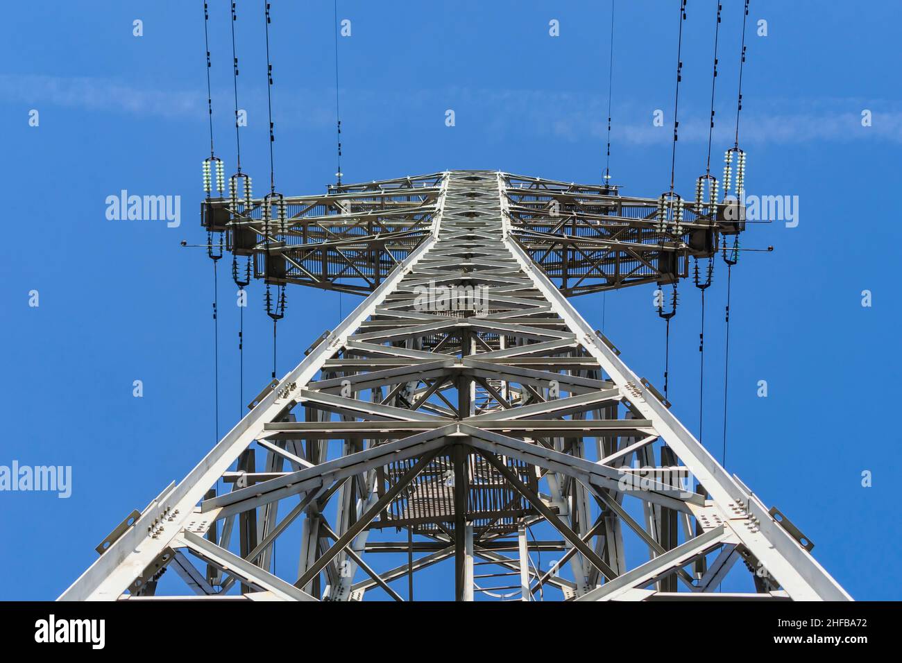 Tall metal electric tower for power transmission against the blue sky ...