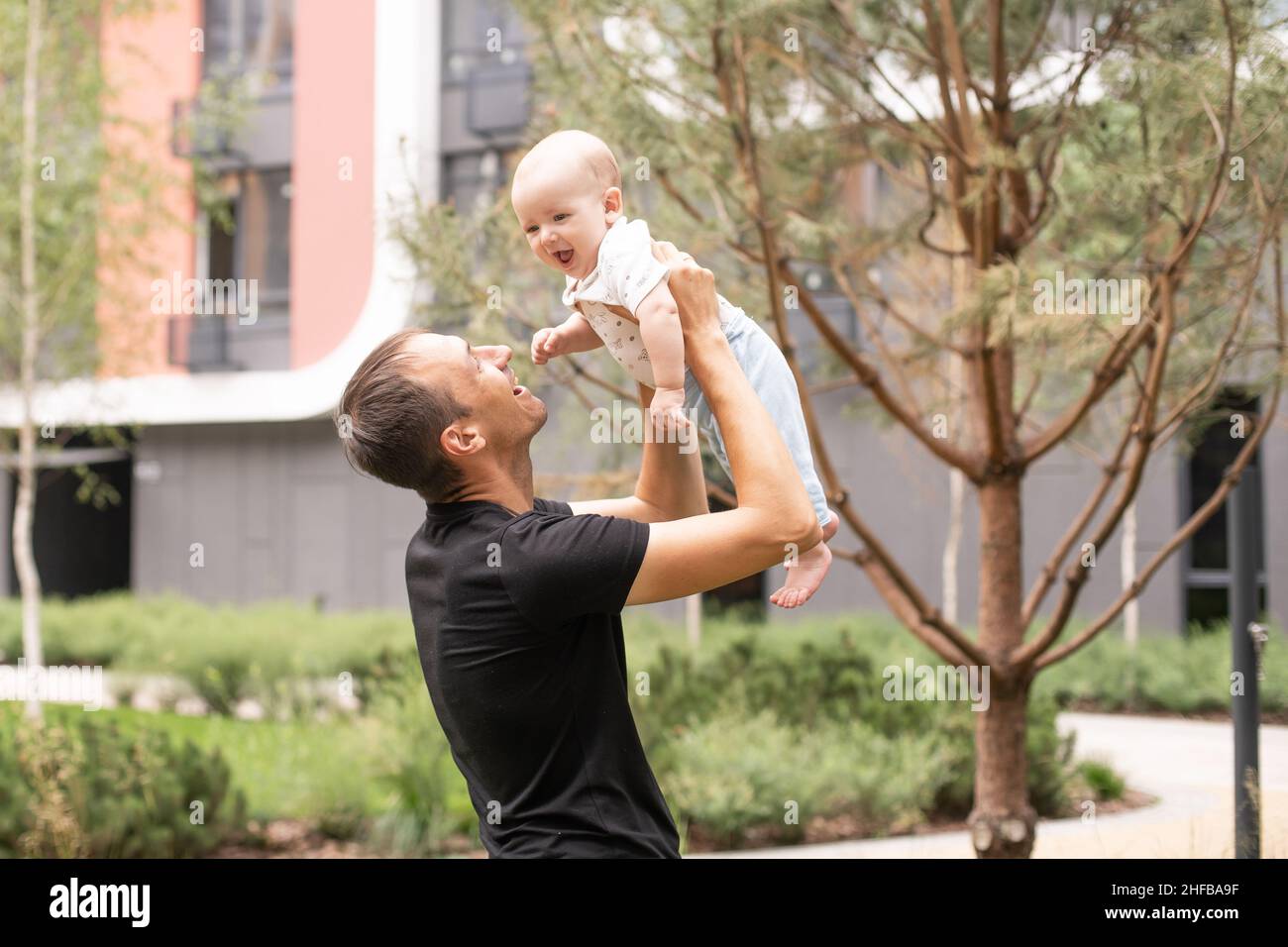 Portrait of young handsome father holding his adorable cute newborn ...