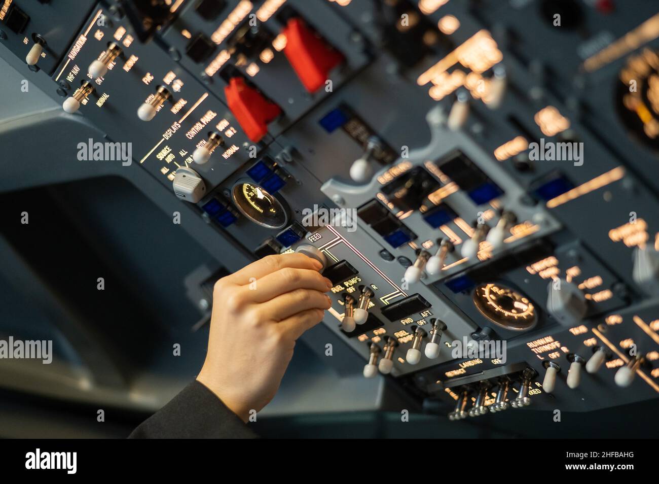 Close-up of a pilot's hand turning a toggle switch on the control panel ...