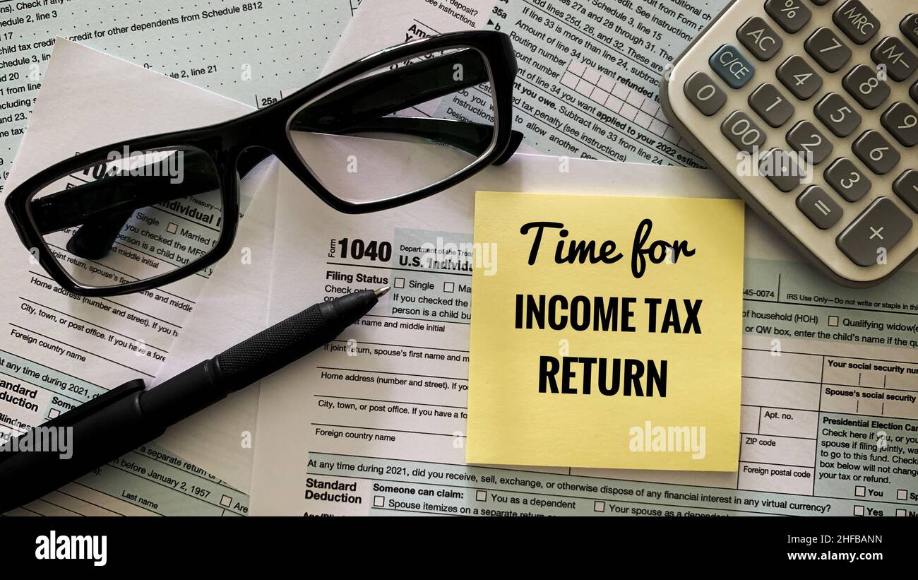 Time for income tax return text on sticky note with tax form ...