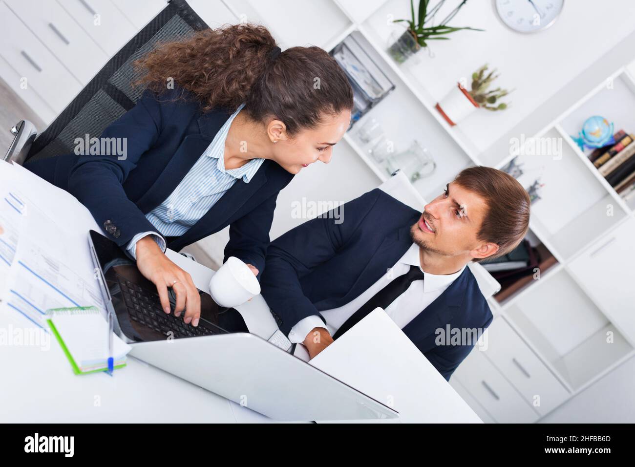 Two business male and female assistants wearing formalwear having work ...