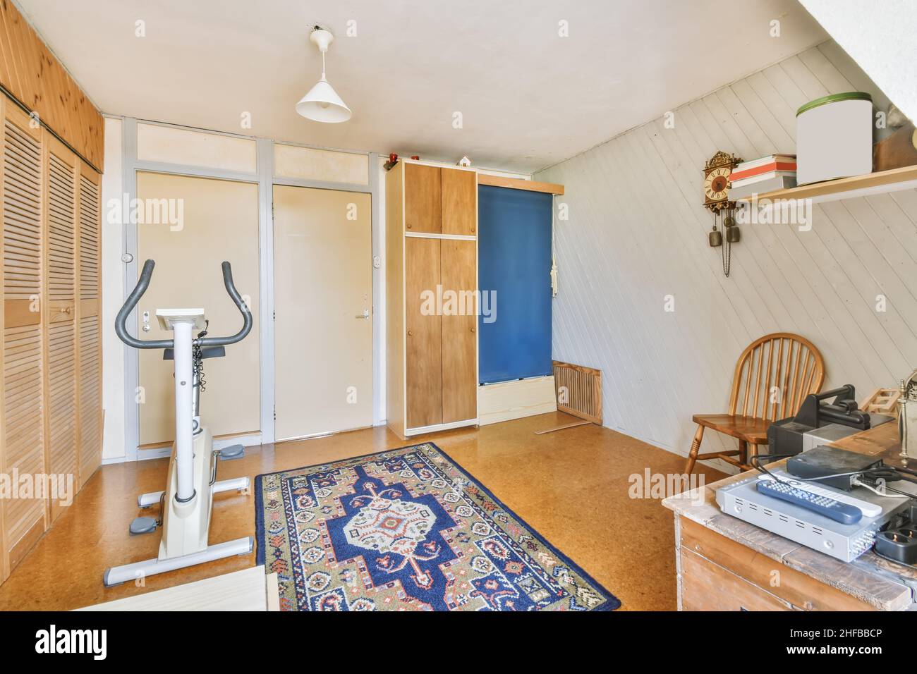Lovely room with exercise machine and wooden cabinet Stock Photo - Alamy