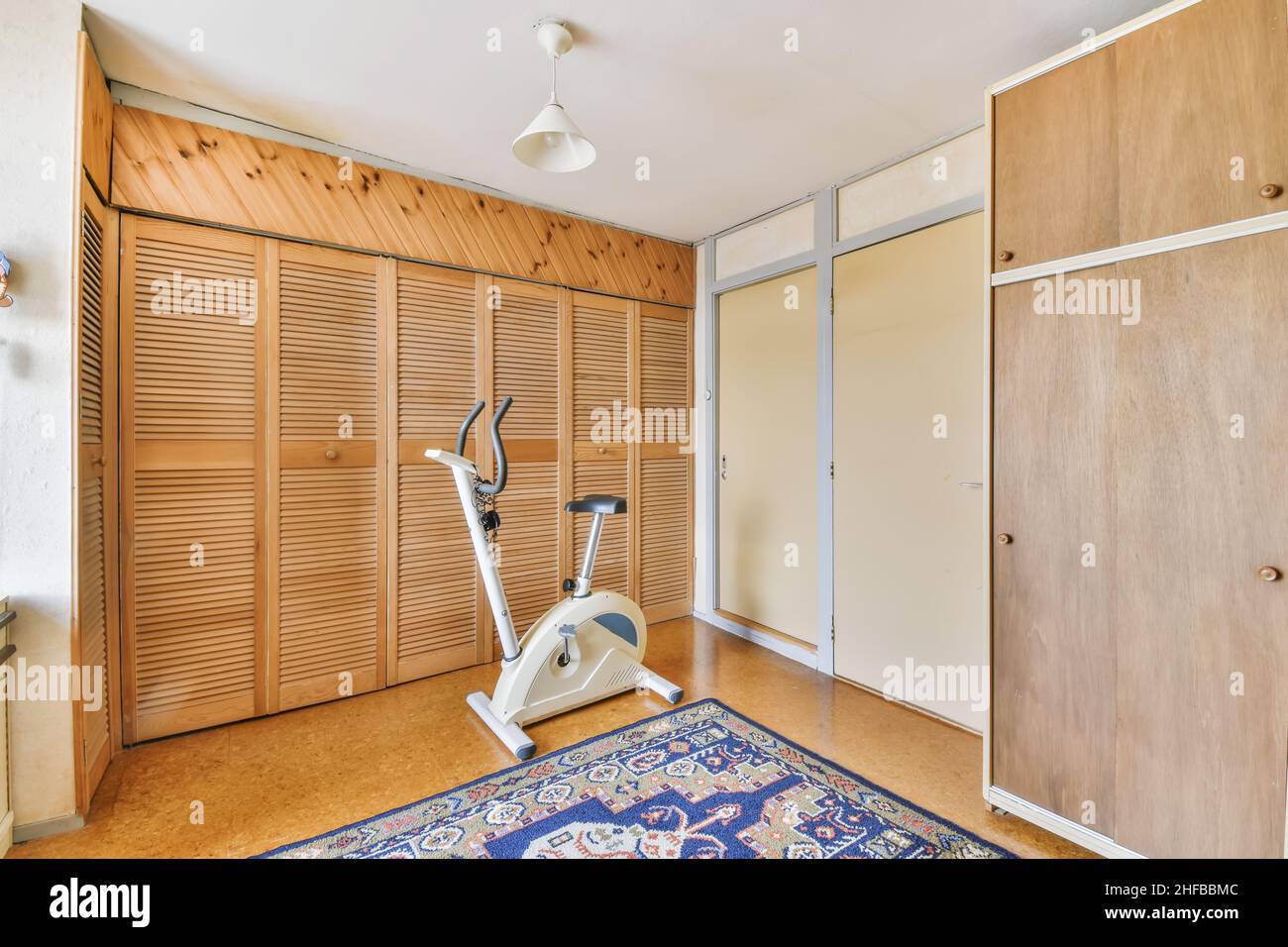 Lovely room with exercise machine and wooden cabinet Stock Photo - Alamy