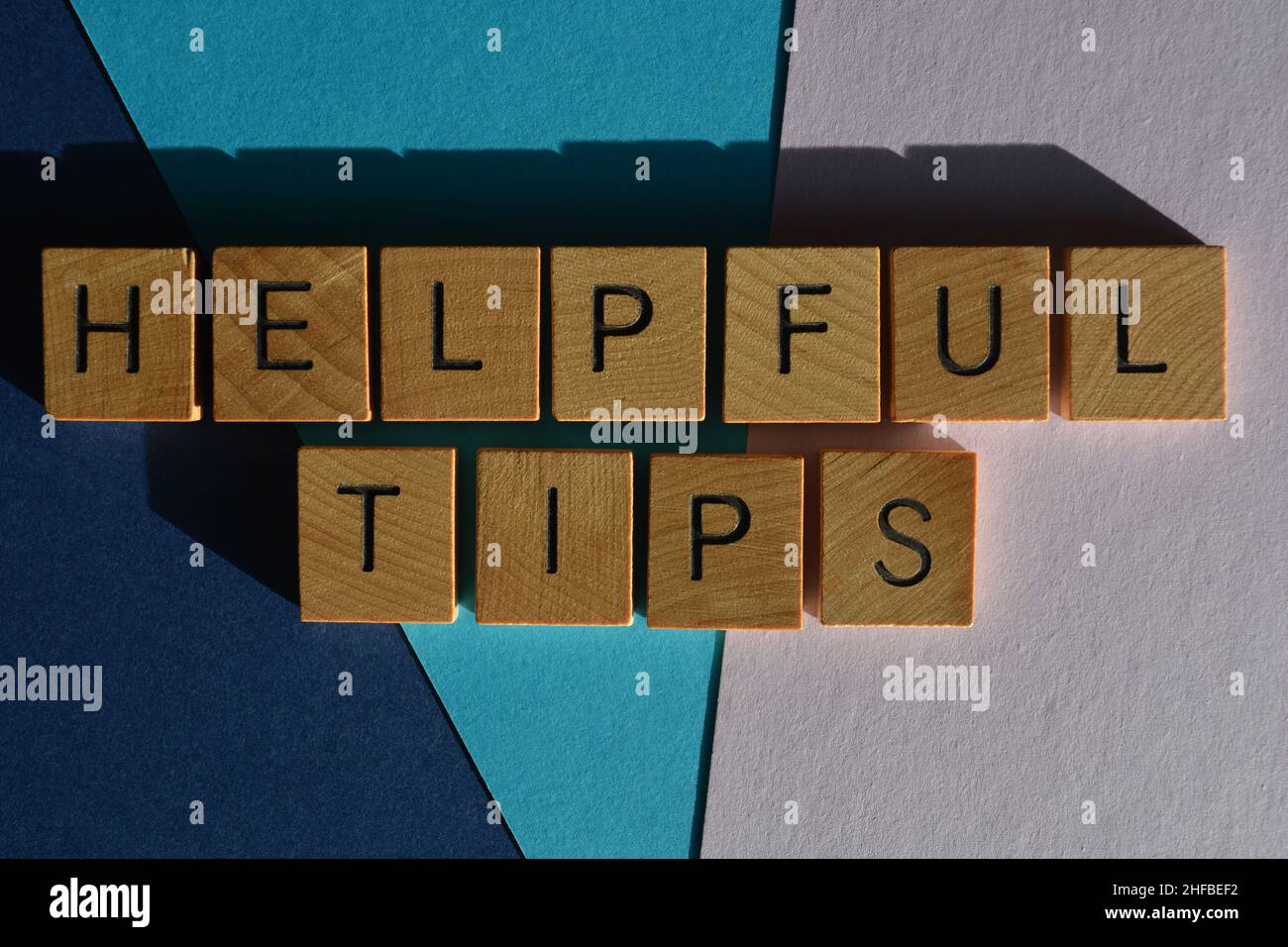 Helpful Tips, phrase in wooden alphabet letters isolated on blue and ...