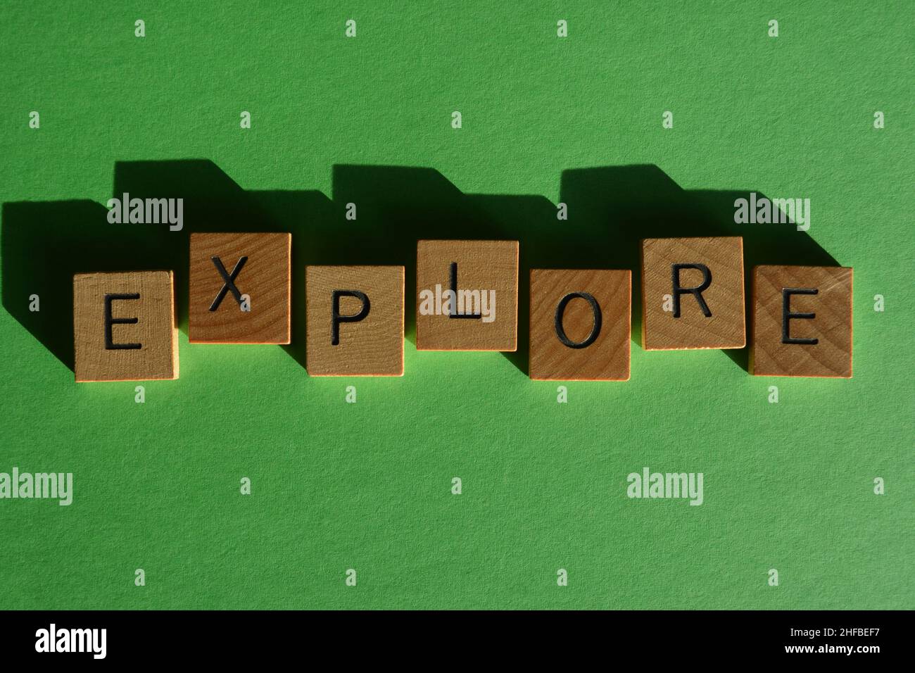Explore, word in wooden alphabet letters isolated on bright green ...