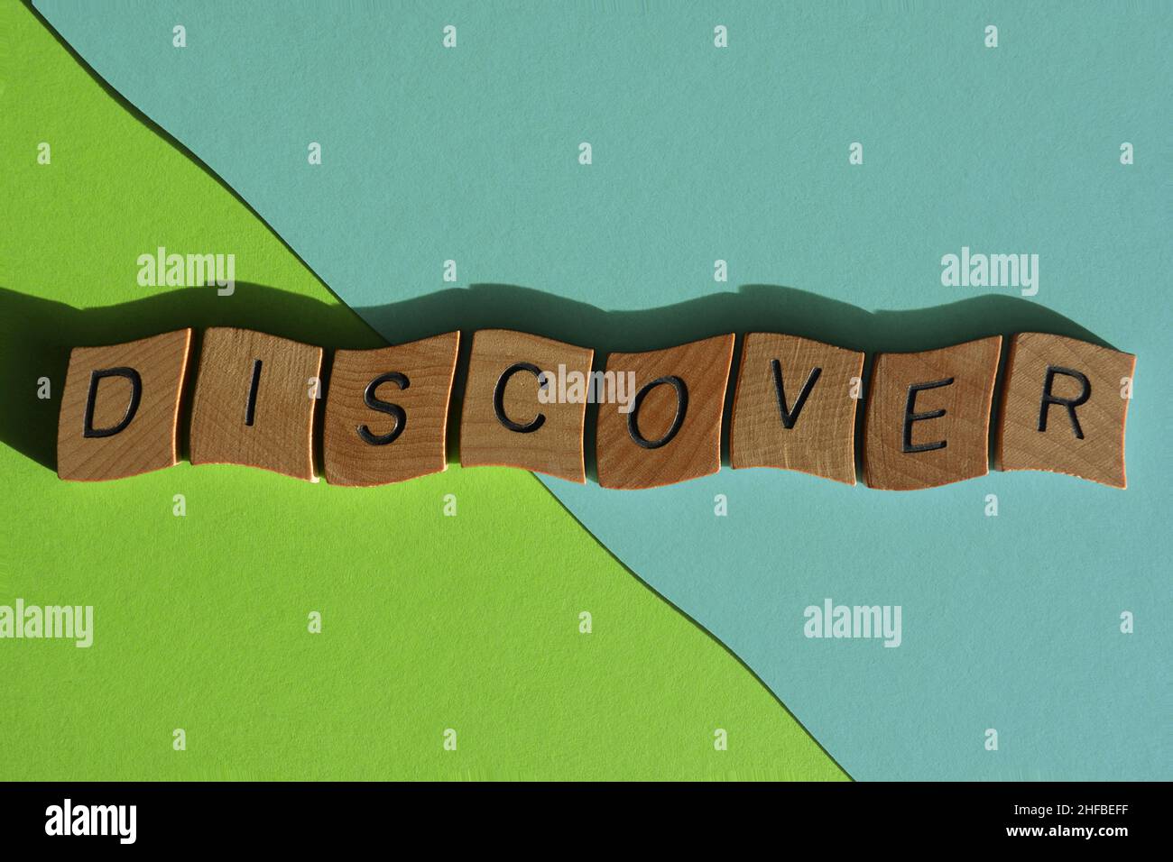 Discover, word in wooden alphabet letters isolated on blue and green ...