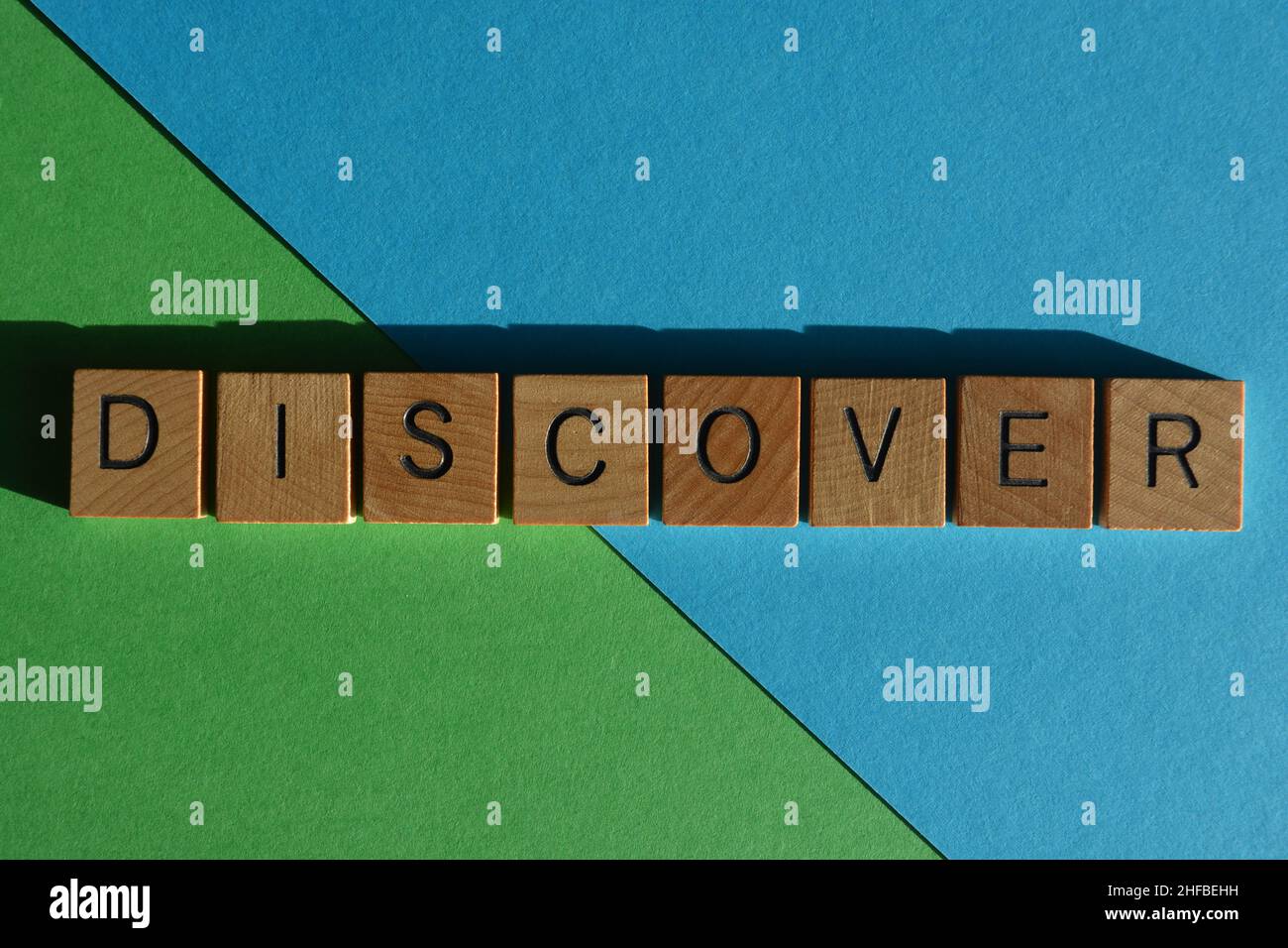Discover, word in wooden alphabet letters isolated on blue and green ...