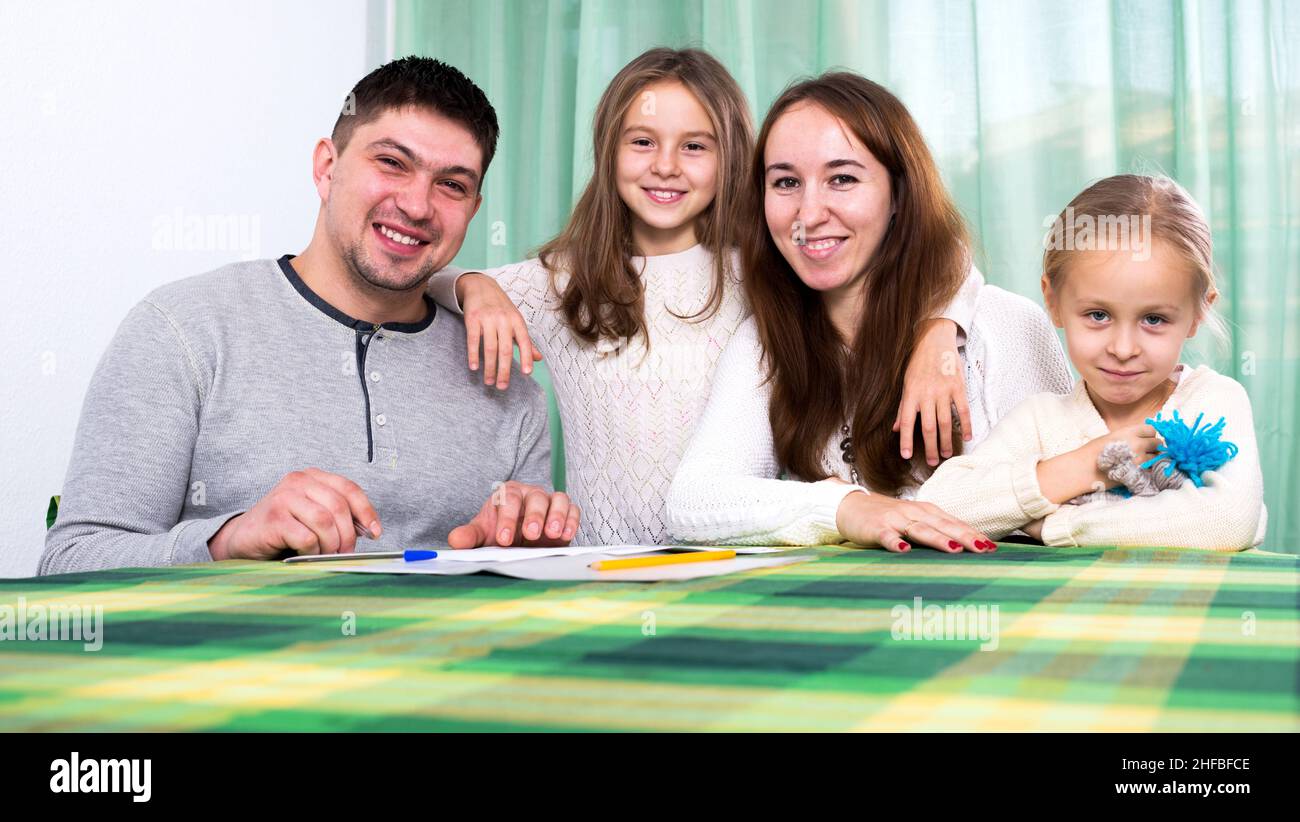 Happy family of four signing documents Stock Photo - Alamy