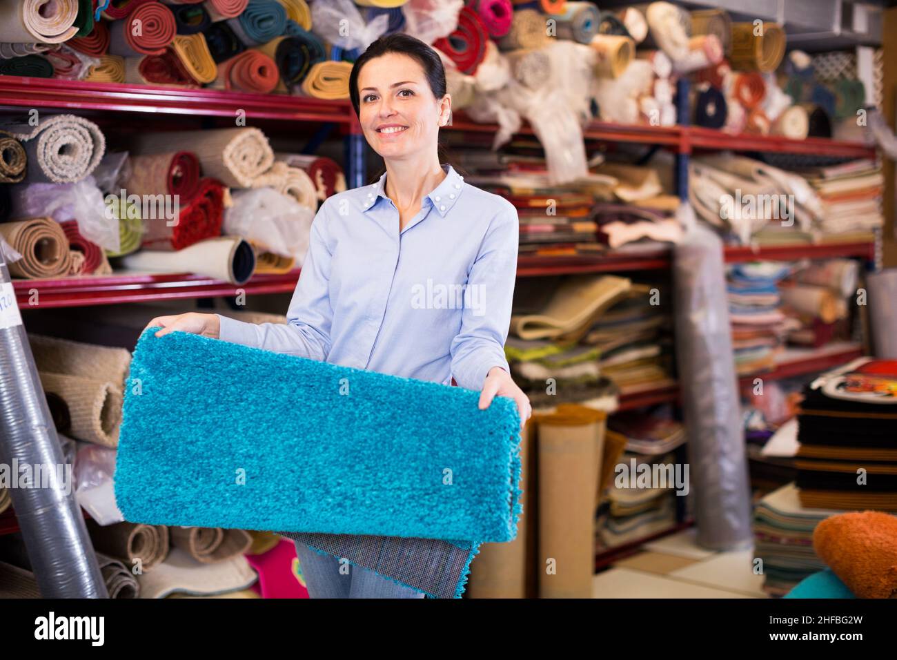 Woman customer shopping carpet in interior stor Stock Photo - Alamy