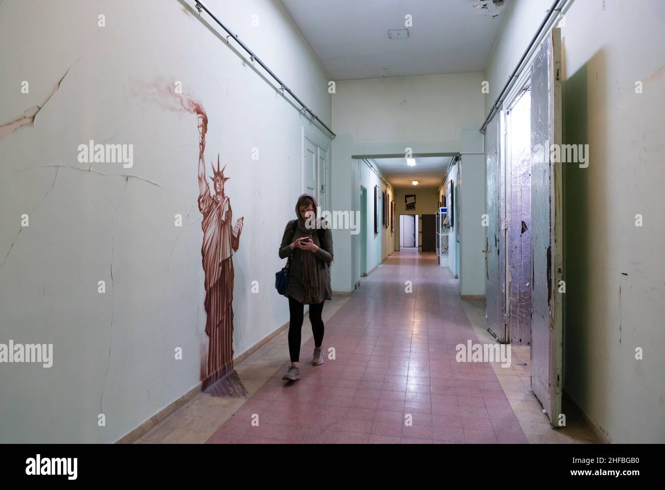 Visitor walking along corridor inside the former US Embassy in Tehran ...